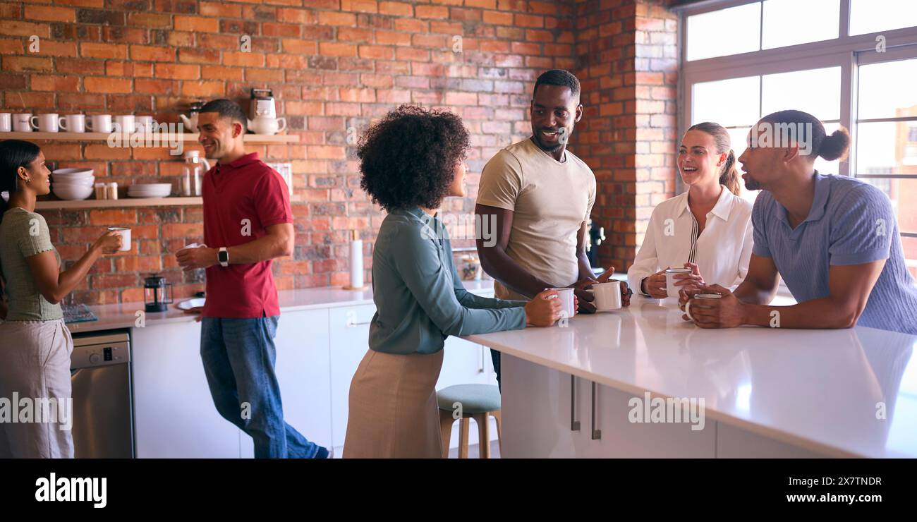 Multi-Cultural Business Team Taking Coffee Break In Kitchen Area Of ...