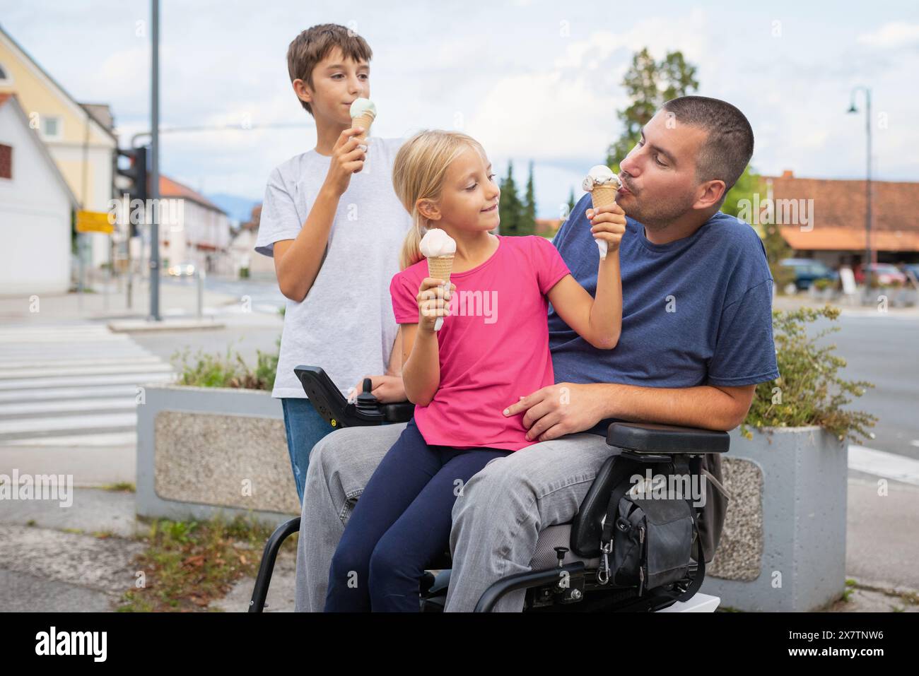 Father with a disability on wheelchair having fun with his kids eating ...