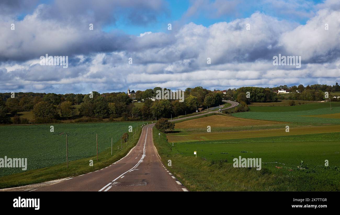 French rural landscape with a country road and a village on the horizon ...