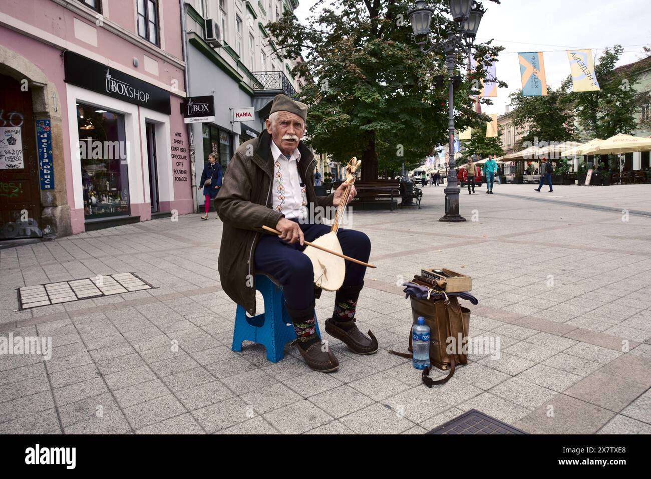 old man playing a "gusle" that is a bowed single-stringed traditional ...