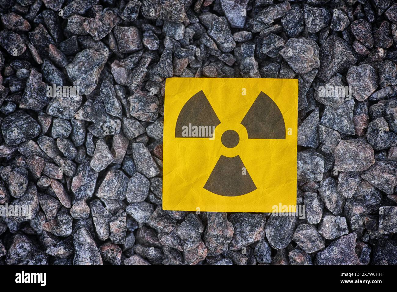 A radiation warning sign on a background of crushed granite. Close up ...
