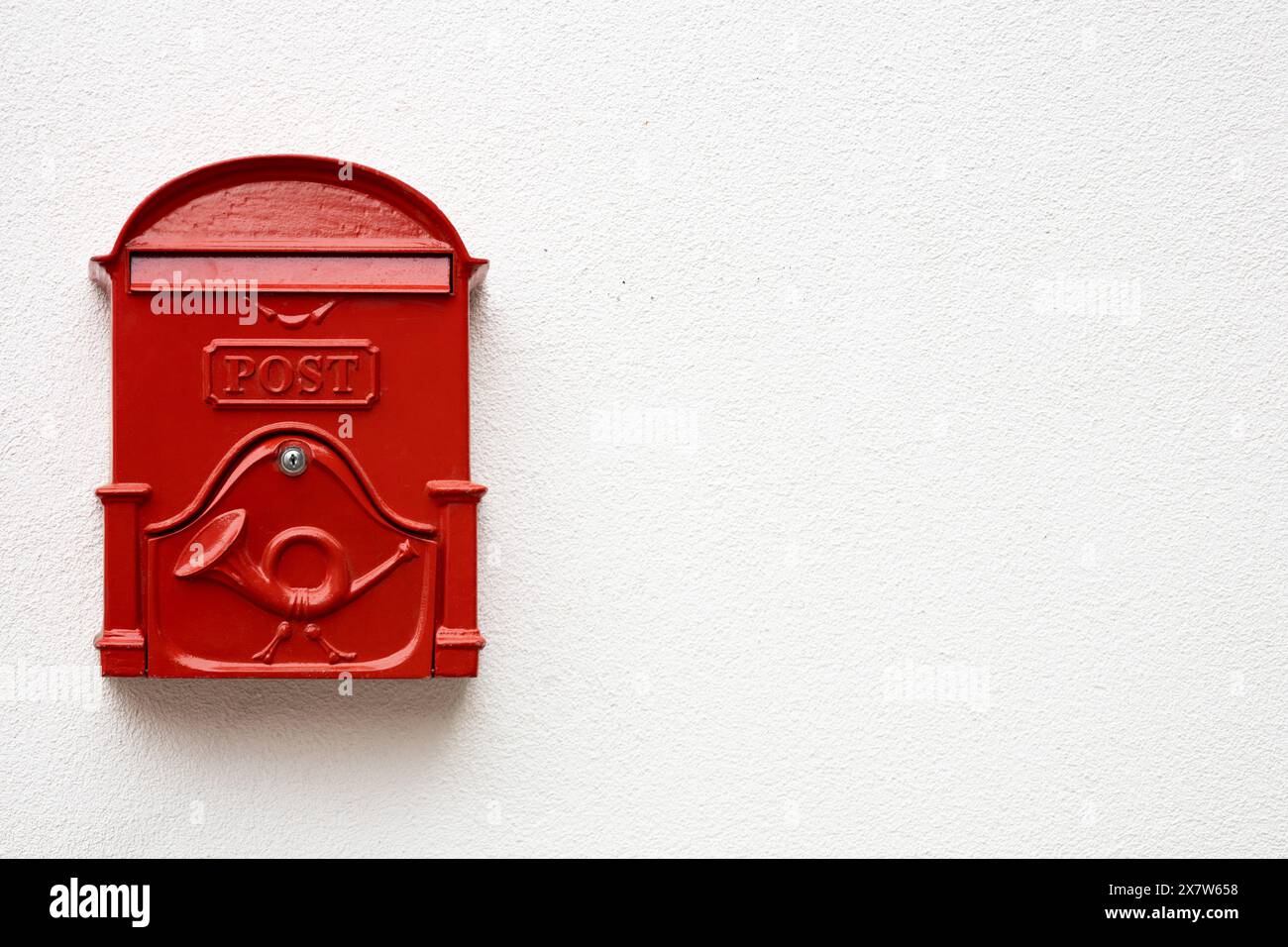 Traditional bright red post box on white plaster texture wall in Hungry ...
