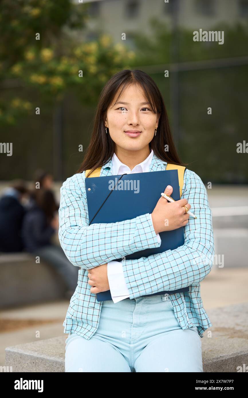 Chinese student at campus university wearing a blue jacket and jeans is ...