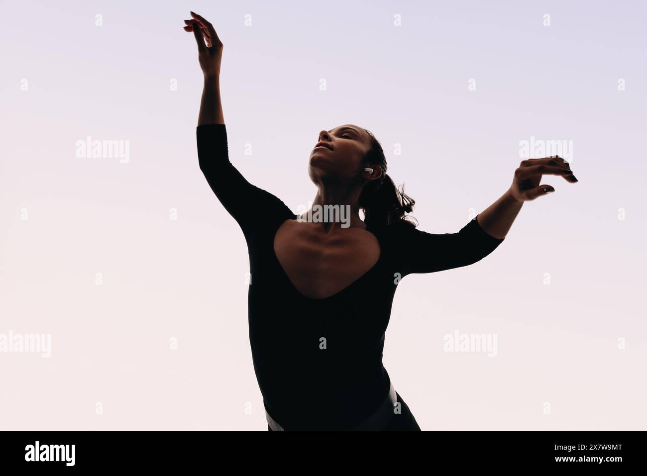 Young woman demonstrating expressive dance moves in a studio. With ...
