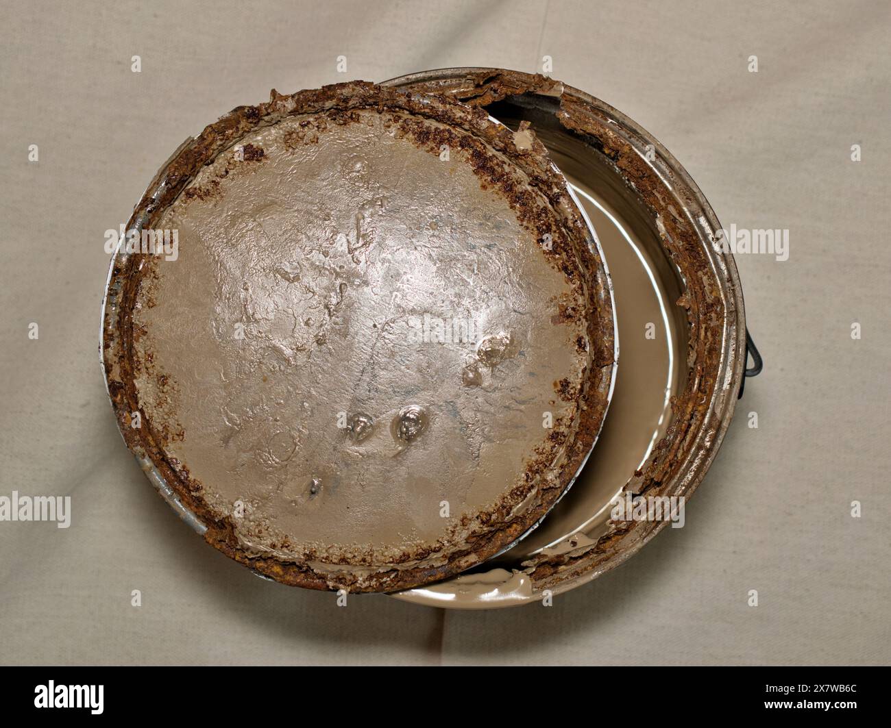 Rusted old metal paint tin with open lid on drop cloth brown expired ...
