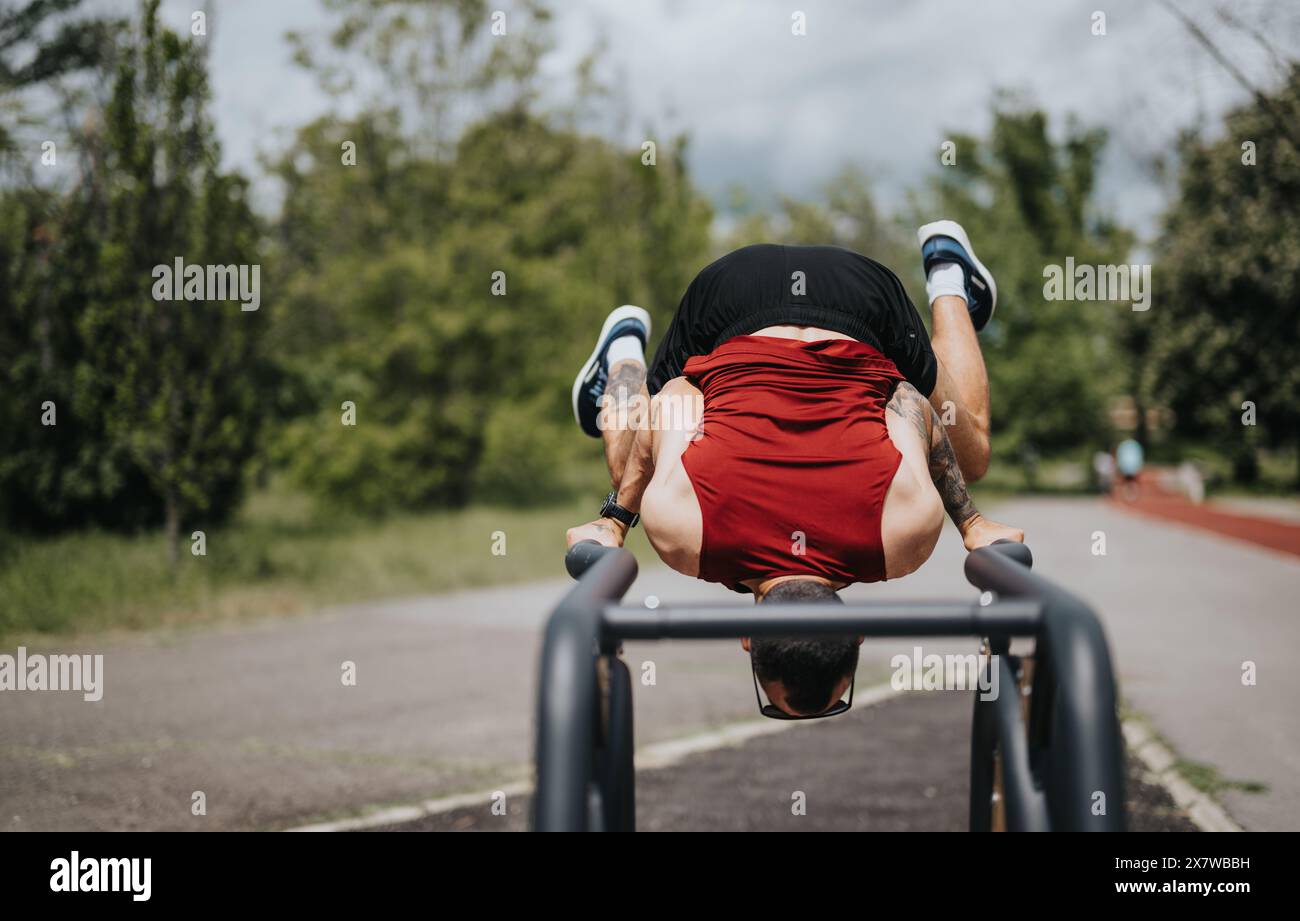 Athletic man performing an advanced calisthenics workout outdoors on ...
