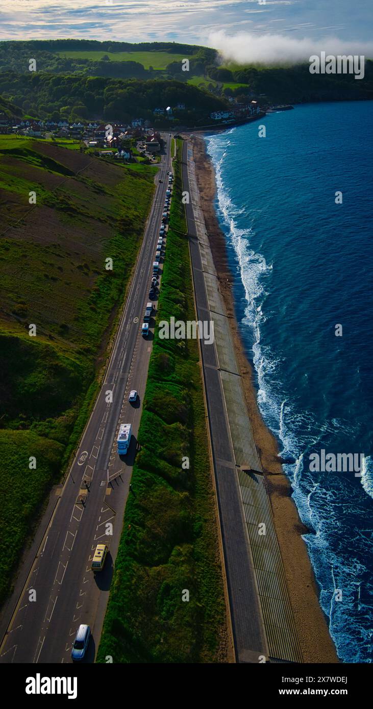 Aerial view of a coastal road with cars, adjacent to a beach and ocean ...