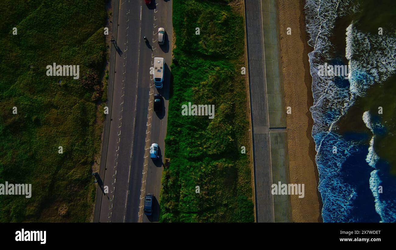 Aerial view of a coastal road with cars parked along the side, adjacent ...