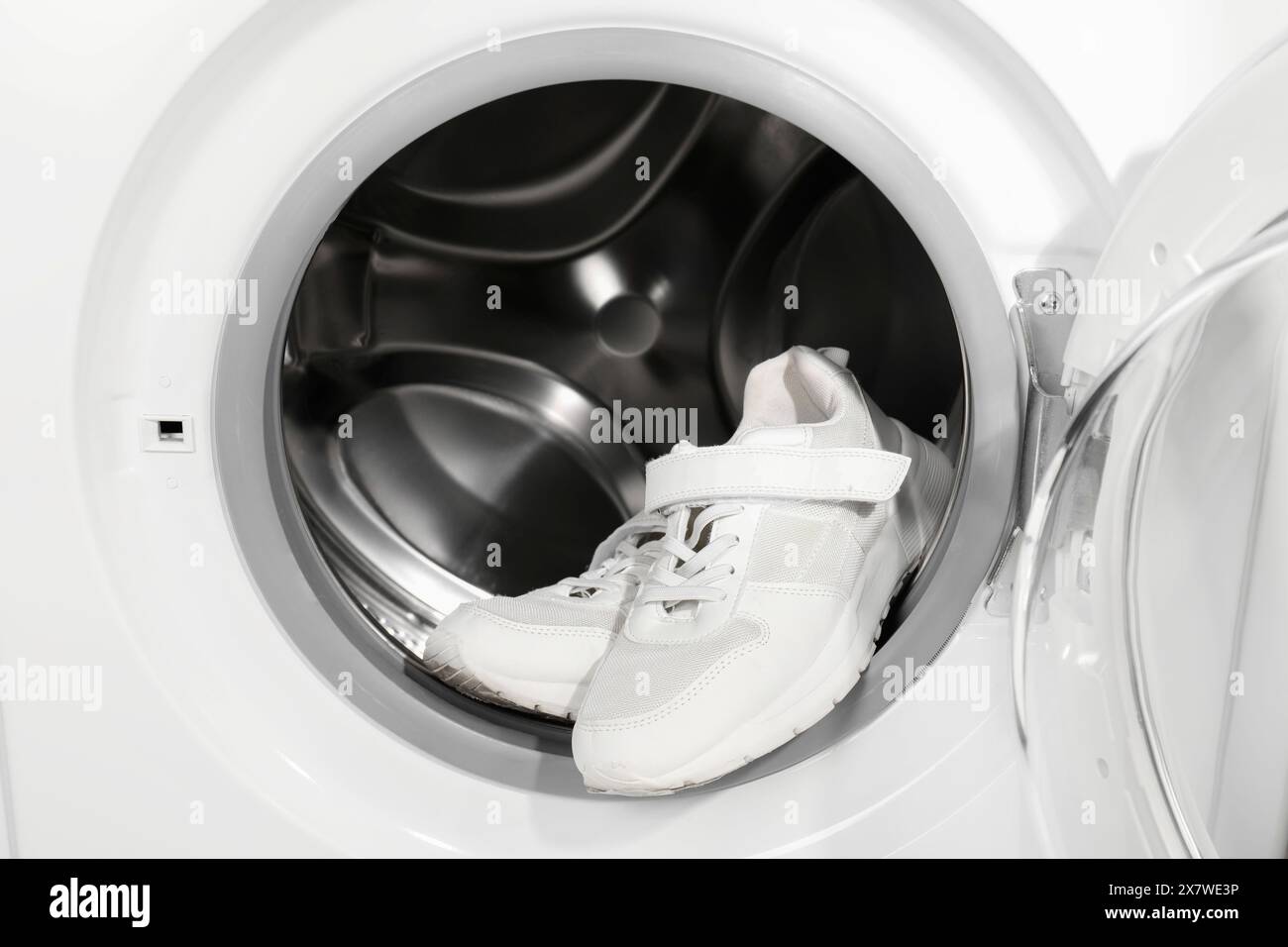 Stylish clean sneakers inside modern washing machine Stock Photo - Alamy