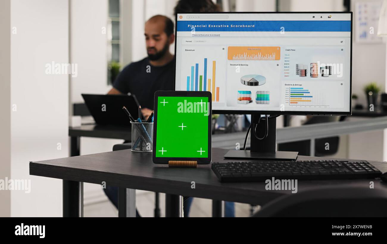 Empty desk with greenscreen tablet and computer running operational ...