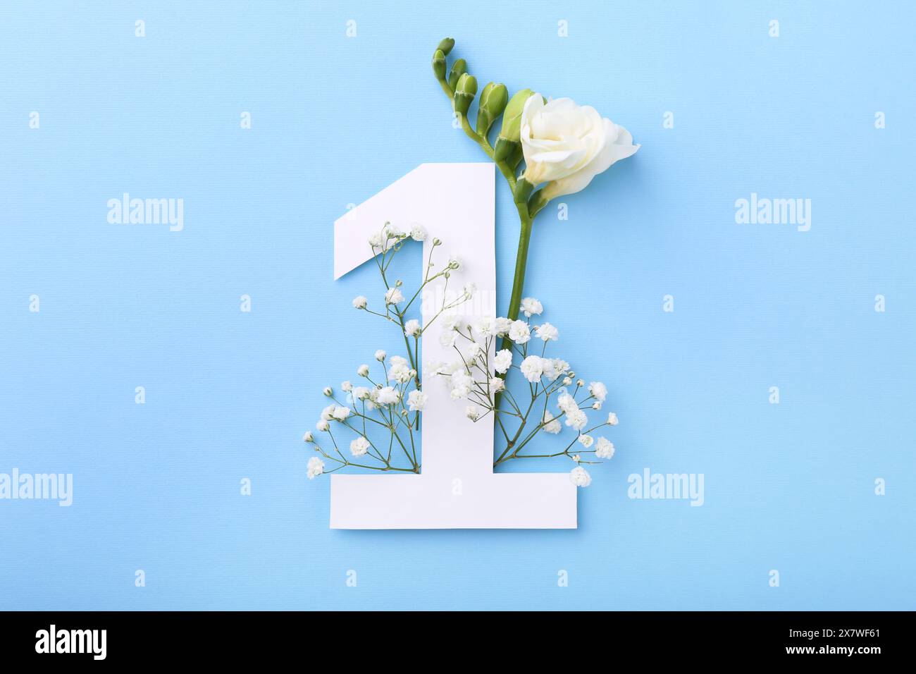 Paper number 1 and beautiful flowers on light blue background, top view ...