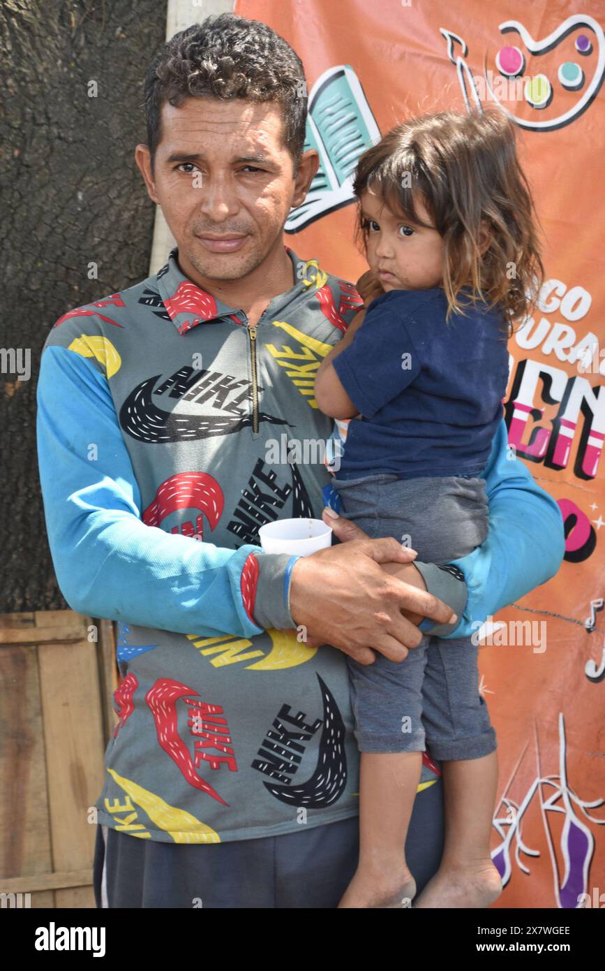 A Venezuelan father poses with his daughter in a migrant encampment in ...