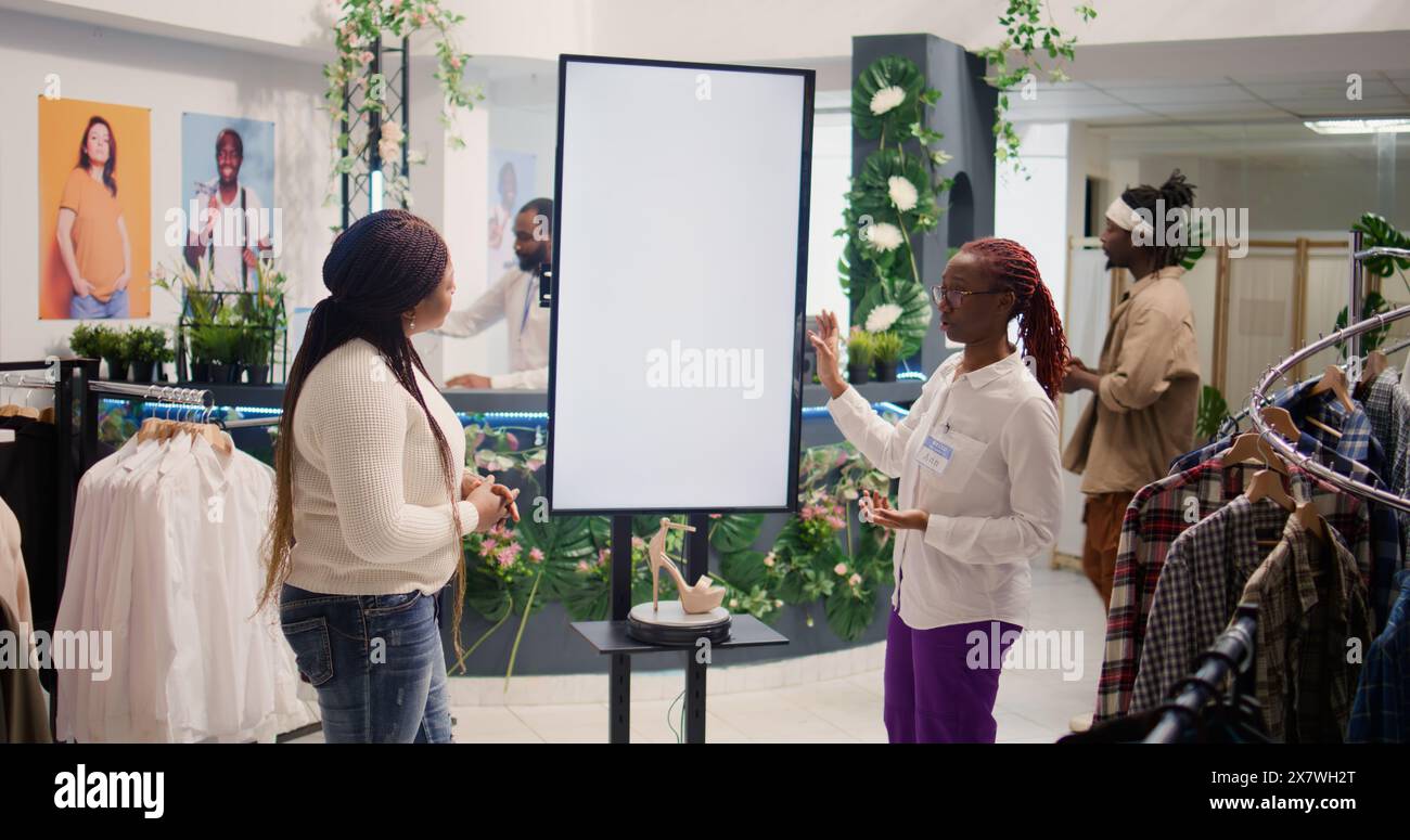 BIPOC shopkeeper in clothing store using augmented reality mockup ...