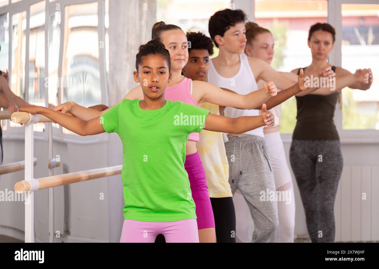 Teenage girl practicing plie position of ballet during choreography ...