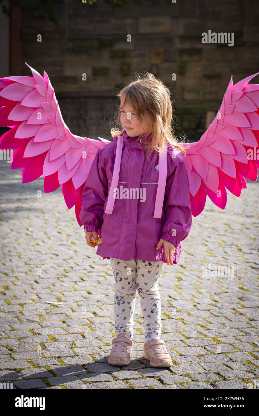 Beautiful young girl wearing pink angel wings. Little cute girl in pink ...