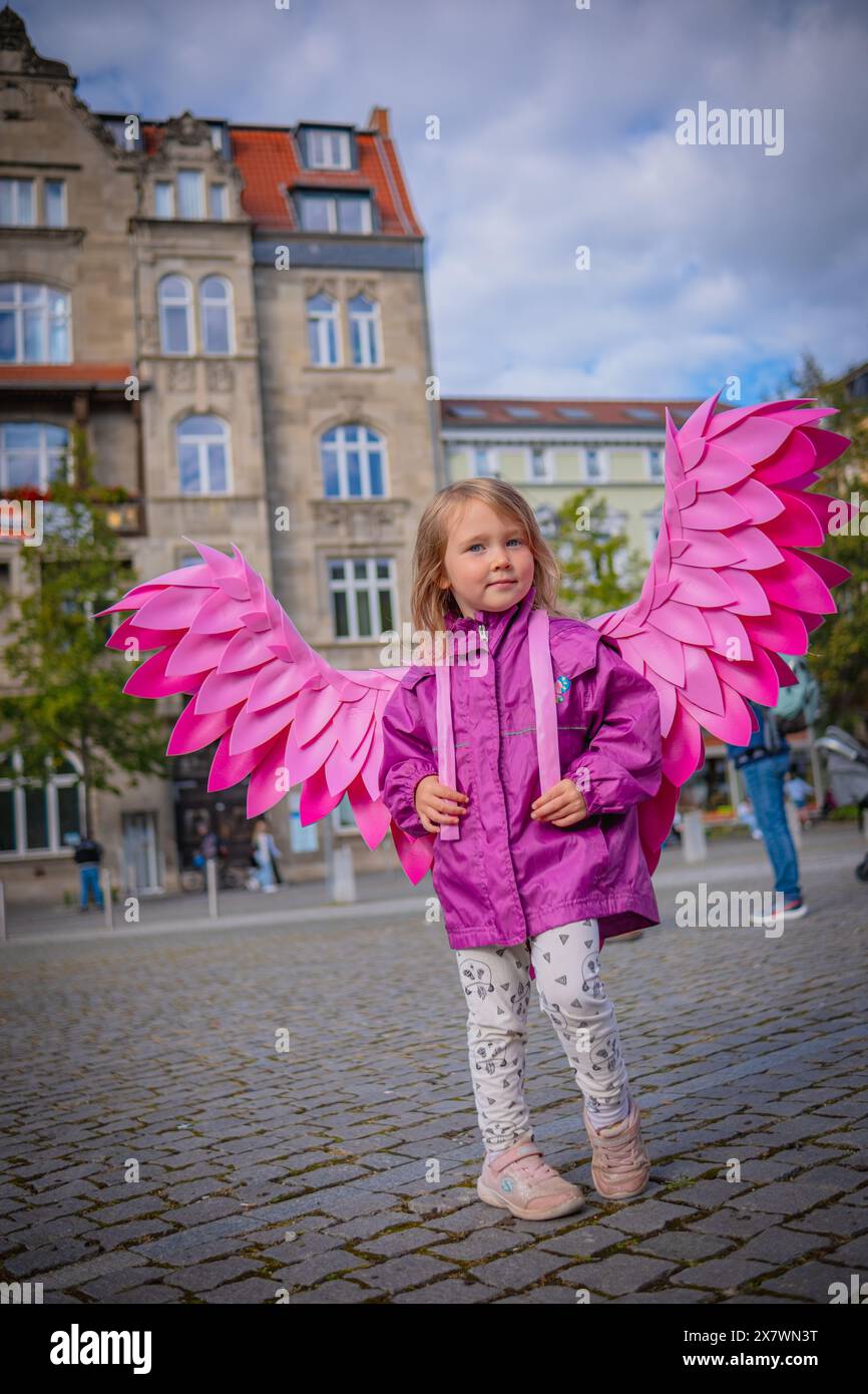 Beautiful young girl wearing pink angel wings. Little cute girl in pink ...