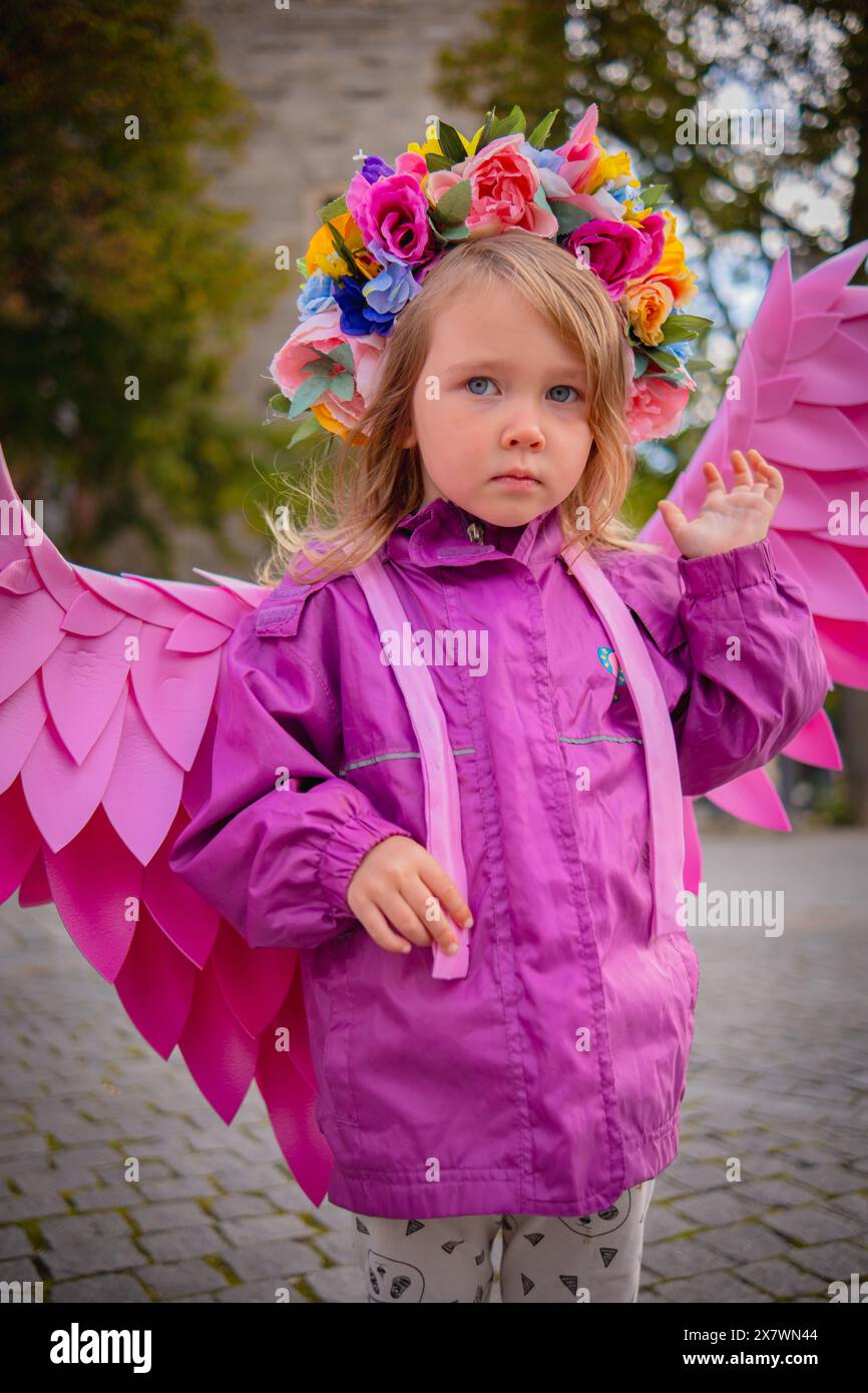 Beautiful young girl wearing pink angel wings. Little cute girl in pink ...