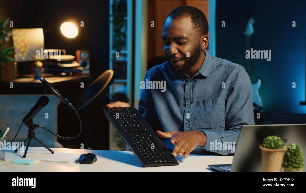 Content creator in dimly lit living room using camera to film keyboard ...