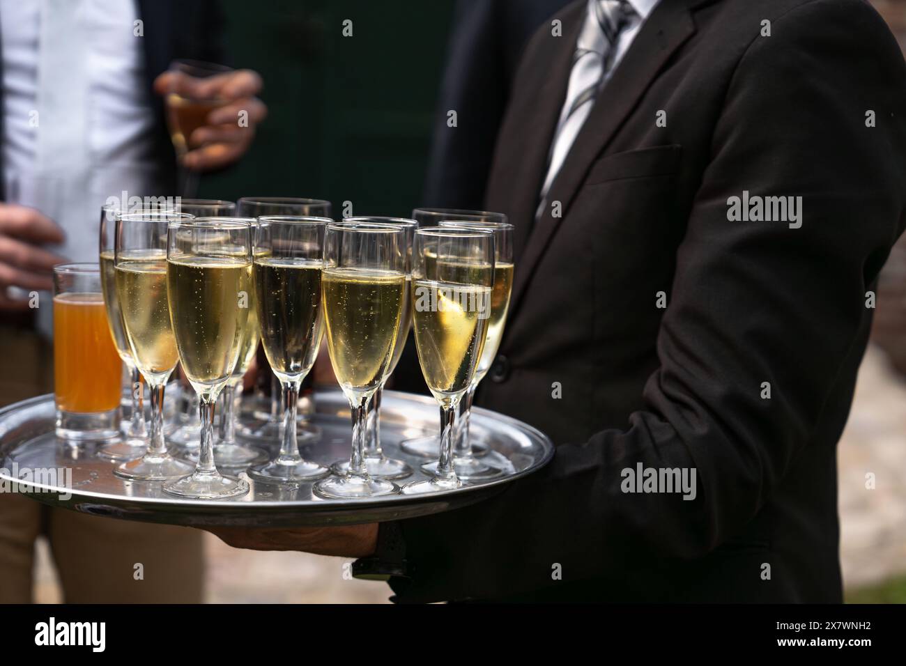 Waiter carrying tray champagne glasses hi-res stock photography and ...