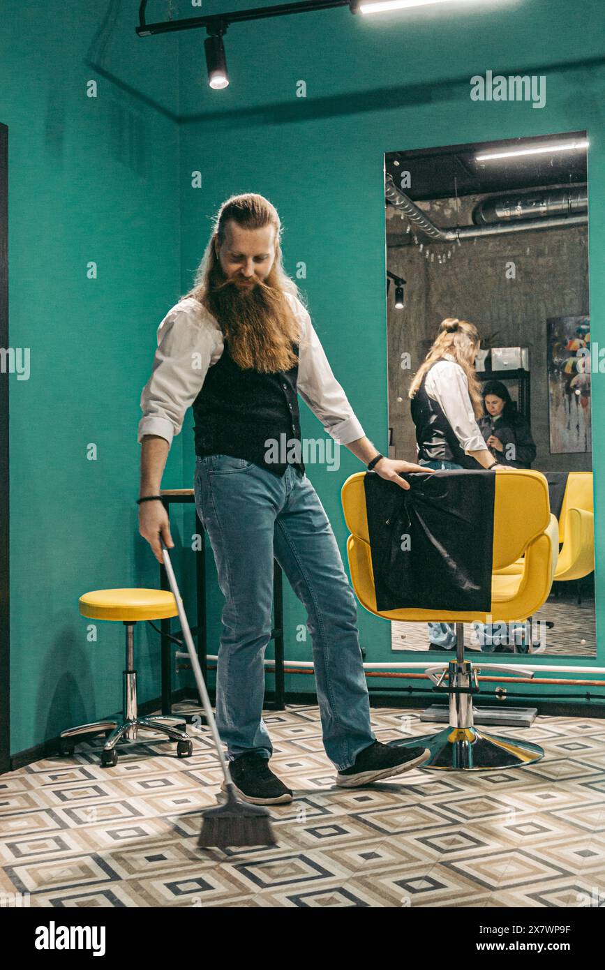Young man sweeping hair salon hi-res stock photography and images - Alamy