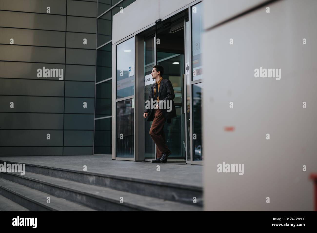 Confident business professional exiting a modern office building, ready ...