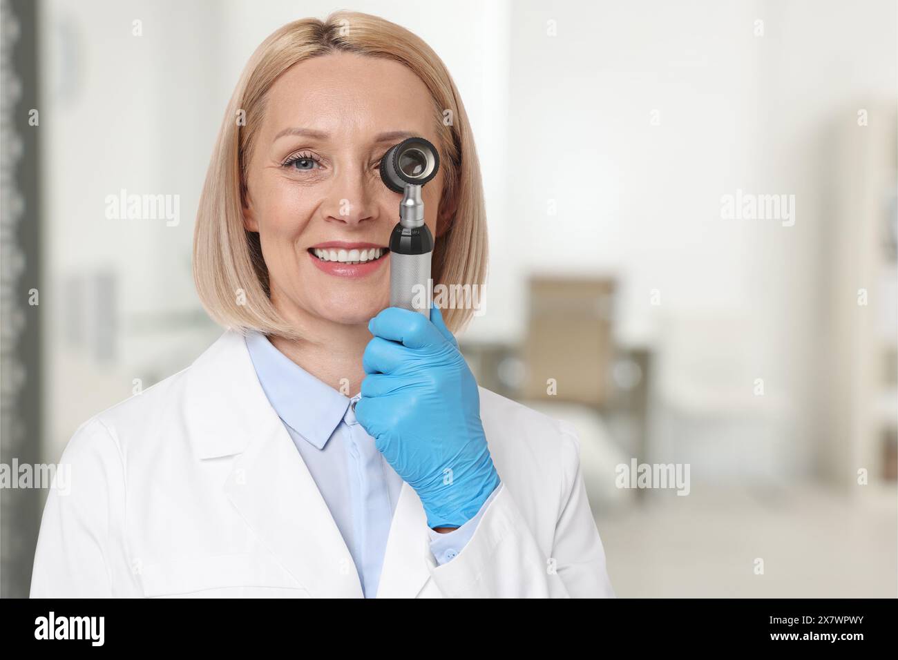 Professional dermatologist with dermatoscope on blurred background ...