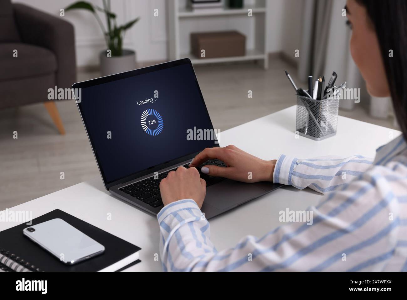 Loading screen displaying progress. Woman working on laptop at table ... Loading screen displaying progress. Woman working on laptop at table ...