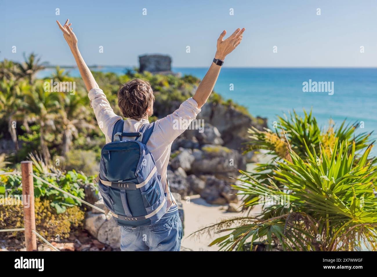 Man tourist enjoying the view Pre-Columbian Mayan walled city of Tulum ...