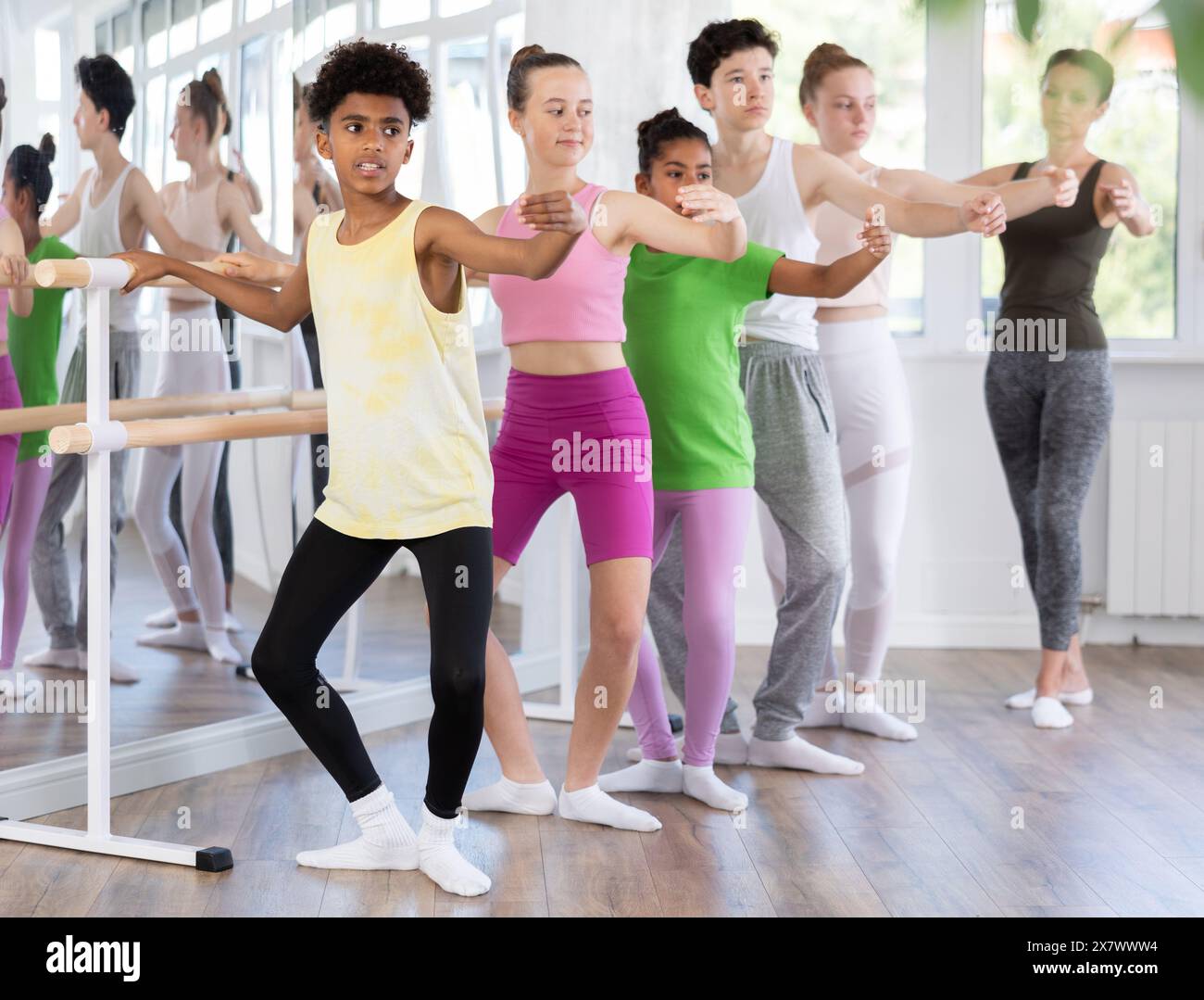 Teenage boy practicing plie position of ballet during choreography ...