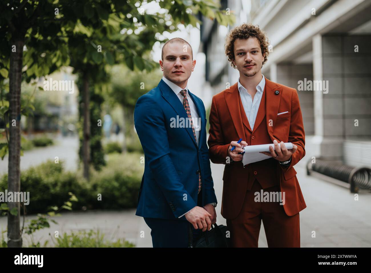 Two businessmen in formal suits discussing business outdoors in a ...
