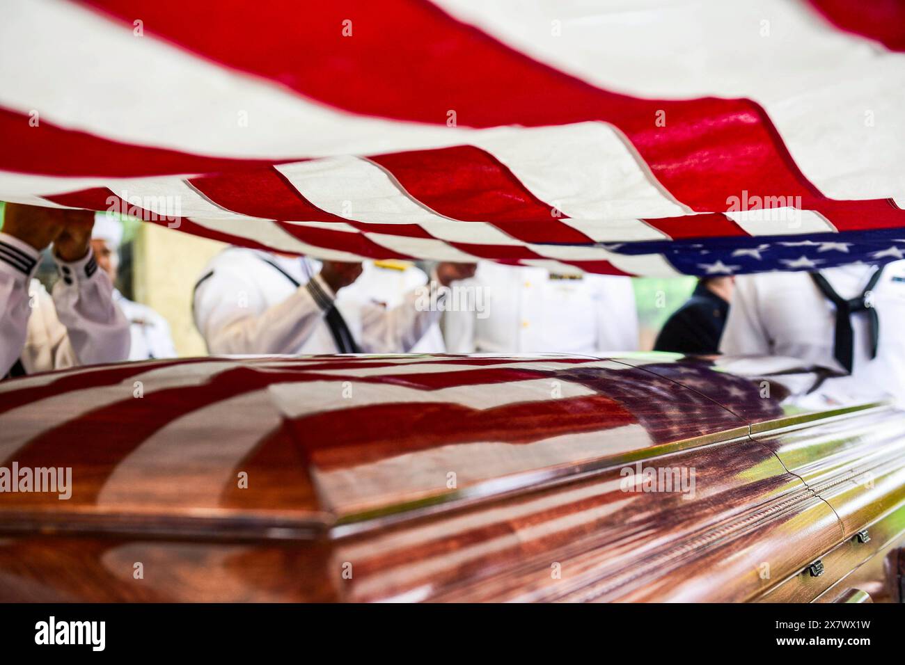U.S. Navy Sailors assigned to Navy Region Hawaii fold an American flag ...