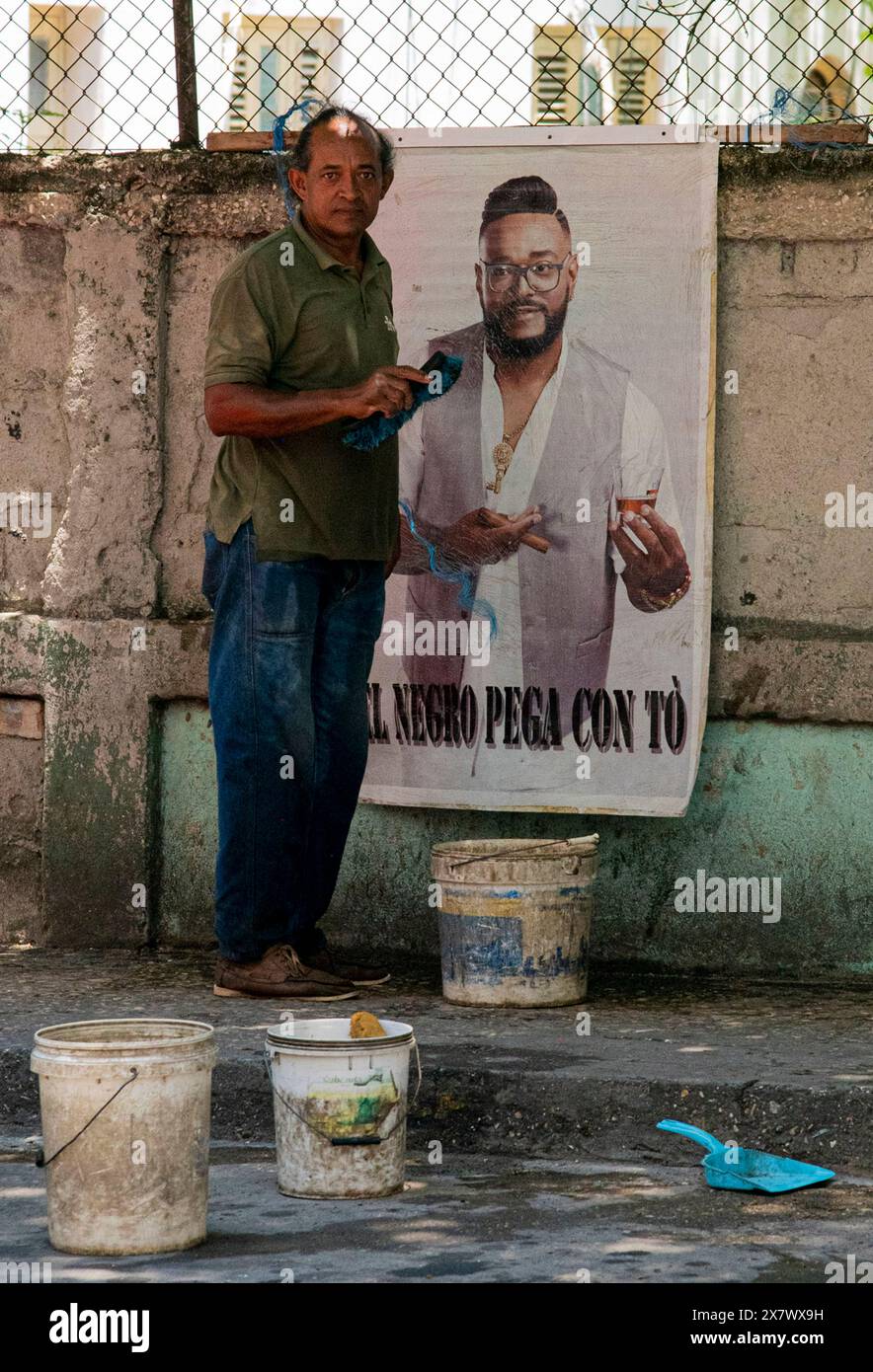 Cuban man cleans the wall after finishing painting a new mural photo in ...