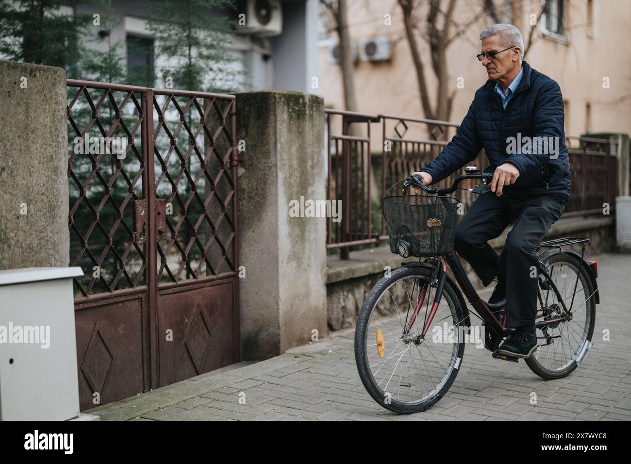 Senior man enjoying a relaxing bike ride in quiet urban area Stock ...