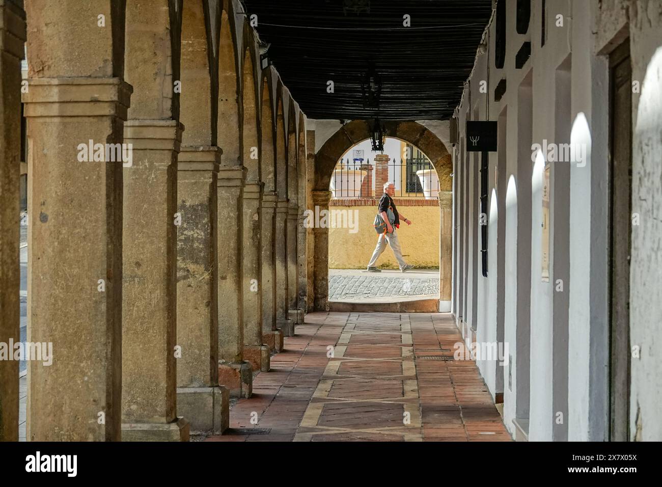 A man walks past the arched arcade at the Arcos Antiguo Claustro Santo ...