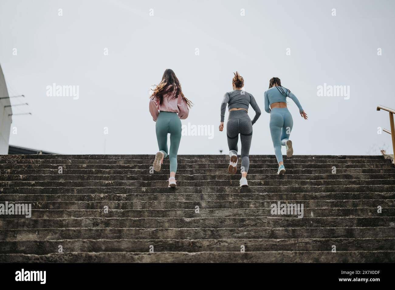 Fitness enthusiasts running up stairs for exercise in athletic attire ...