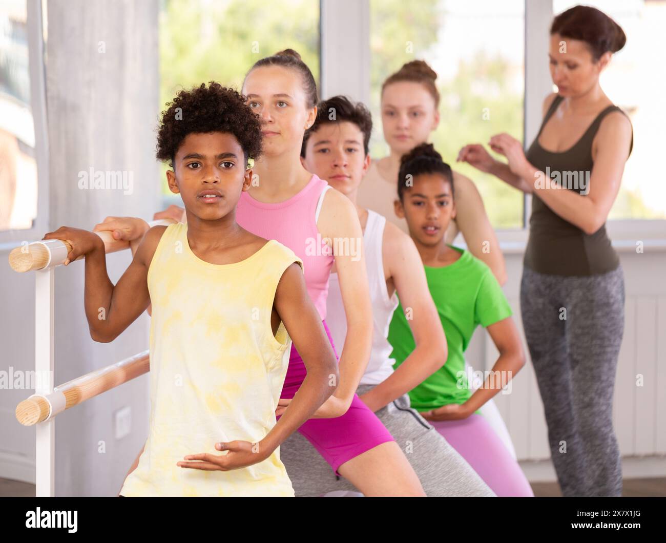 Teenage boy practicing plie position of ballet during choreography ...