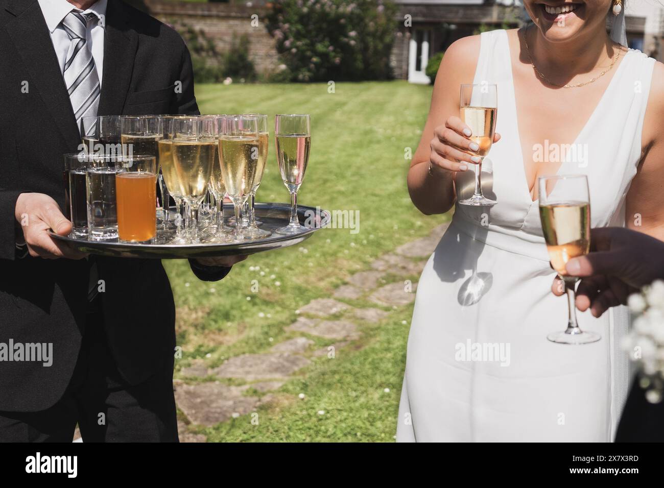 A waiter serving champagne at a wedding for the bride and a groom Stock ...