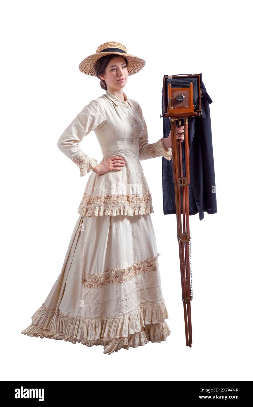 Young woman with camera wearing a beige vintage 1880s dress and straw ...