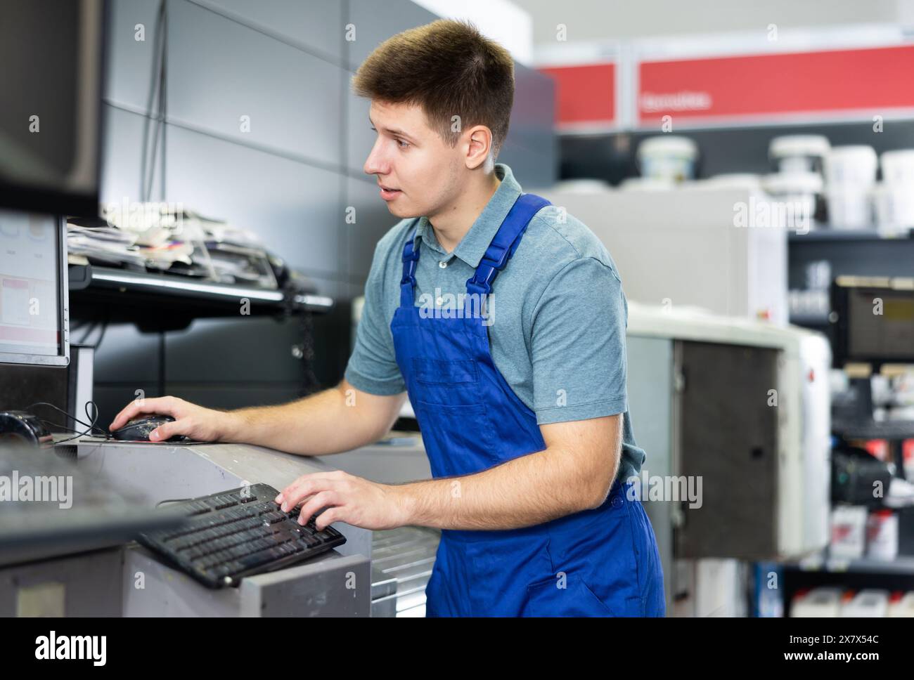 Warehouse guy employee look at computer monitor screen and check ...