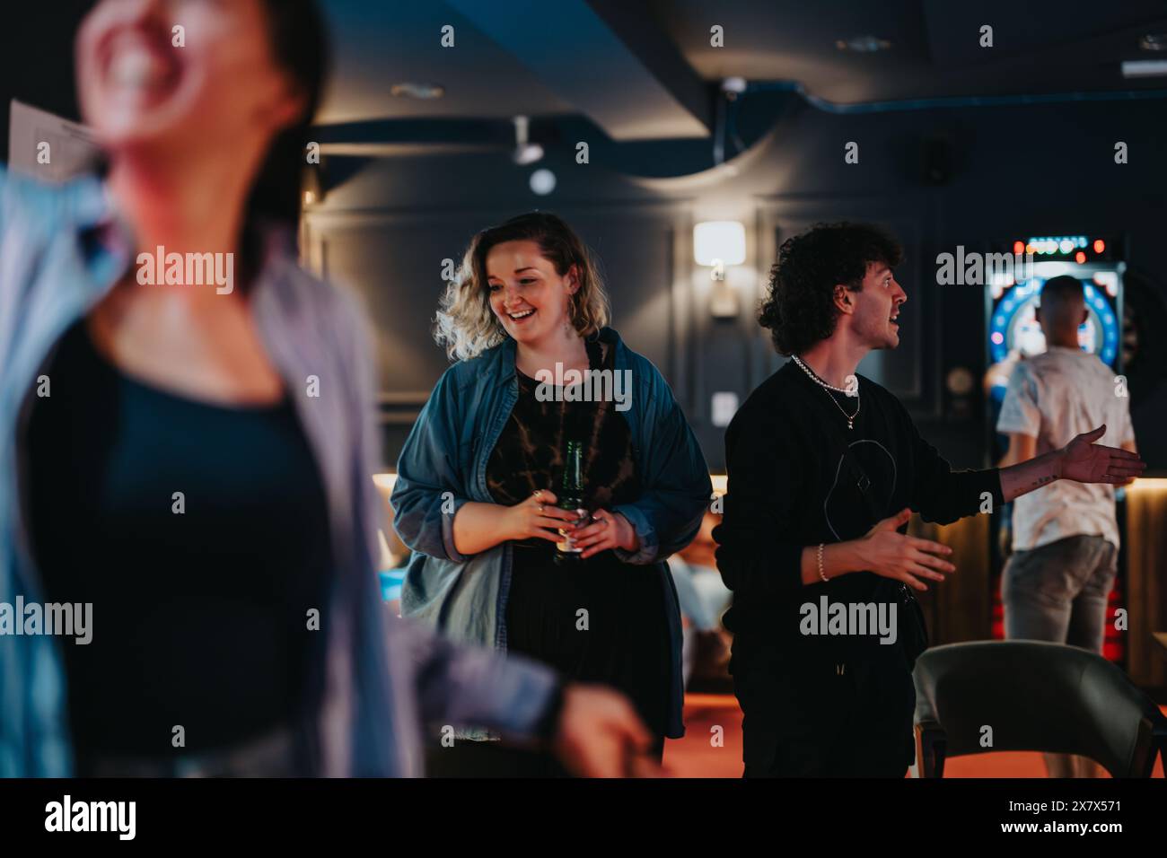 Friends sharing laughter during a fun darts game on a joyful night out ...