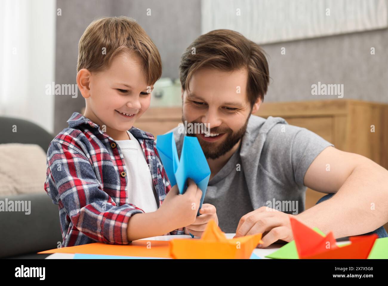 Happy dad and son making paper figures at home Stock Photo - Alamy