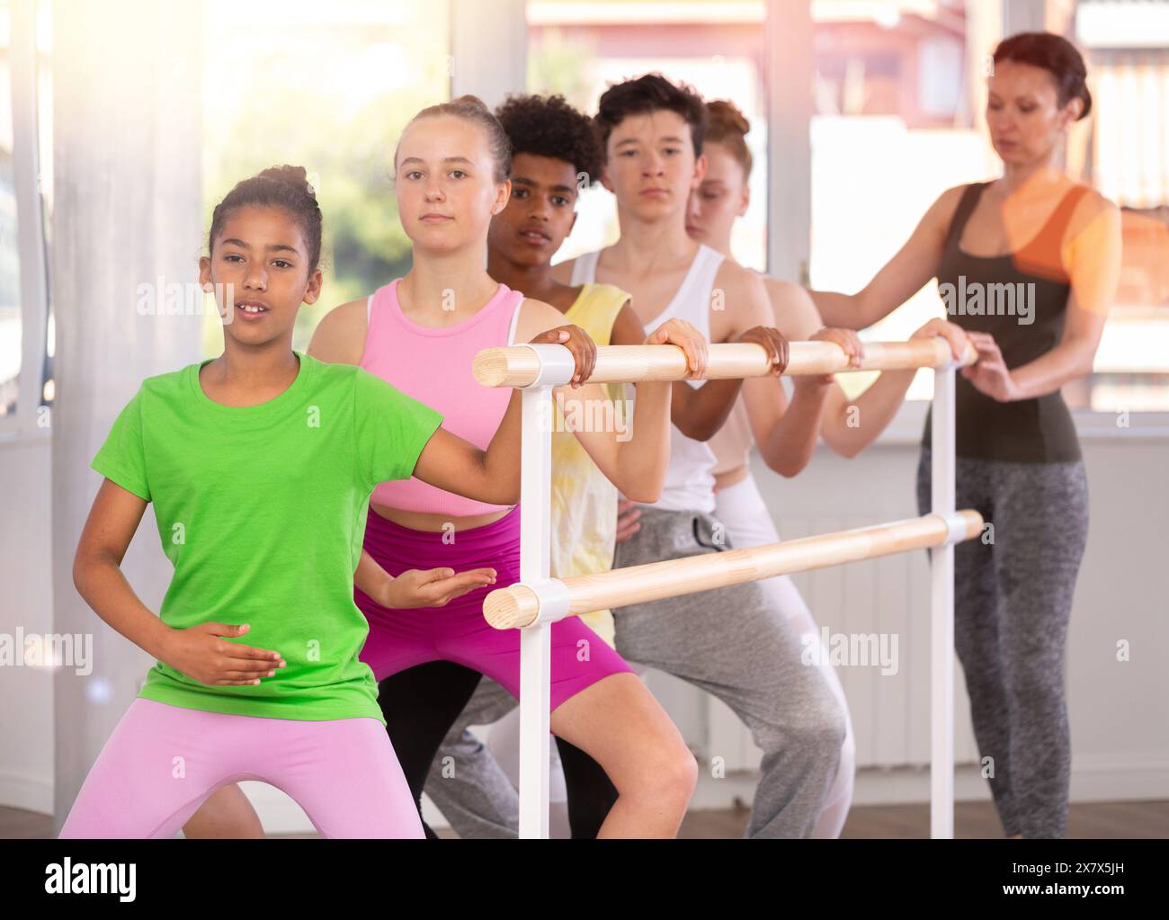 Teenage girl practicing plie position of ballet during choreography ...