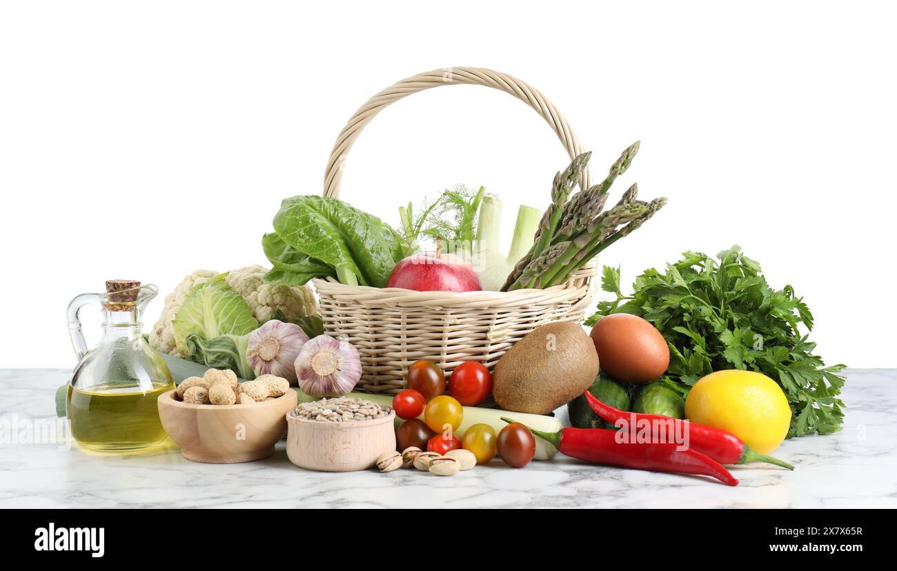 Healthy food. Basket with different fresh products on marble table ...