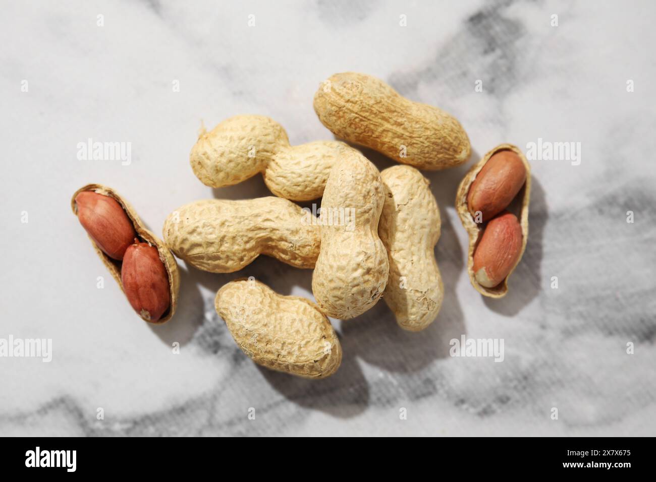 Fresh unpeeled peanuts on white marble table, top view Stock Photo - Alamy
