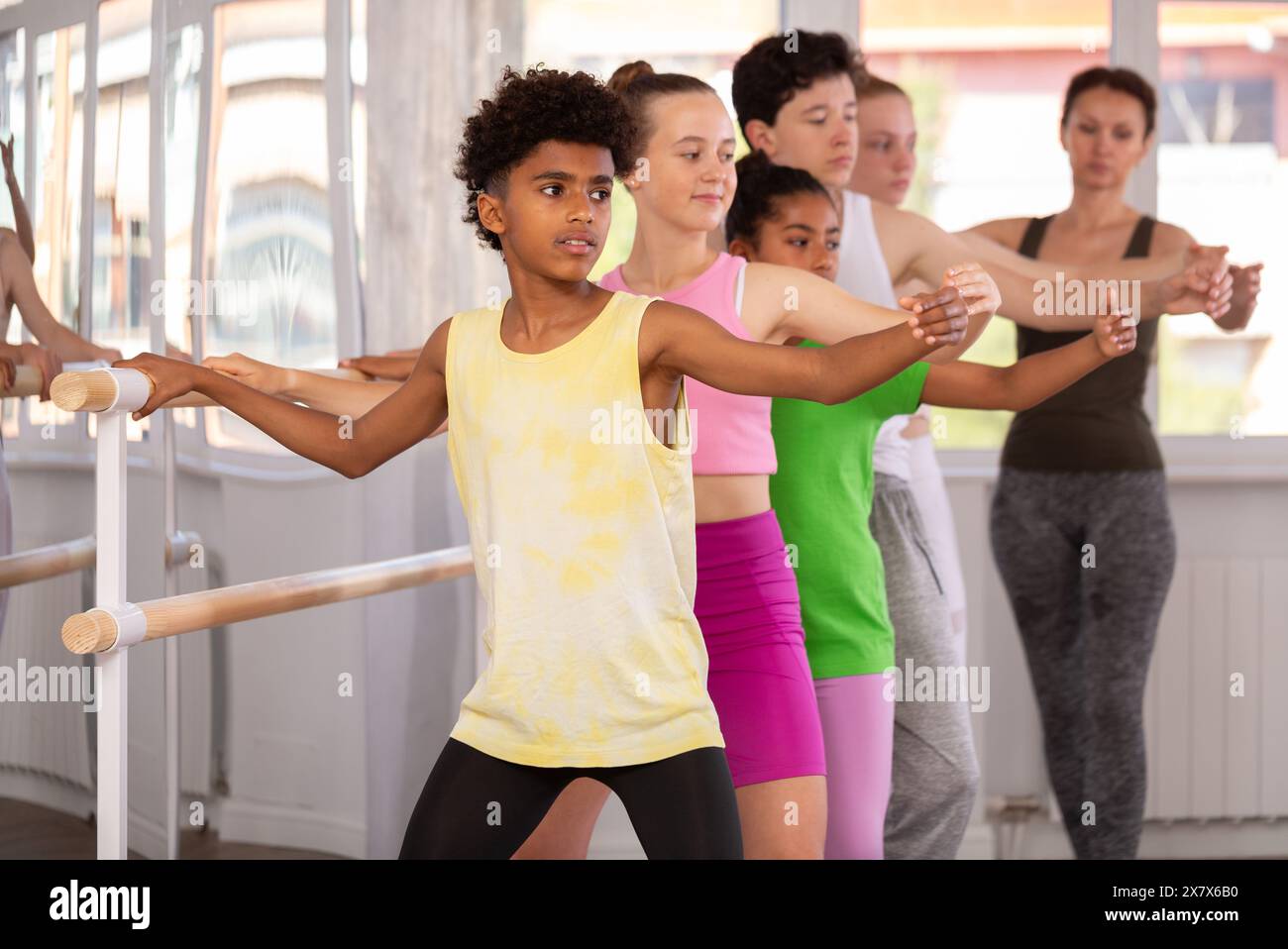 Teenage boy practicing plie position of ballet during choreography ...