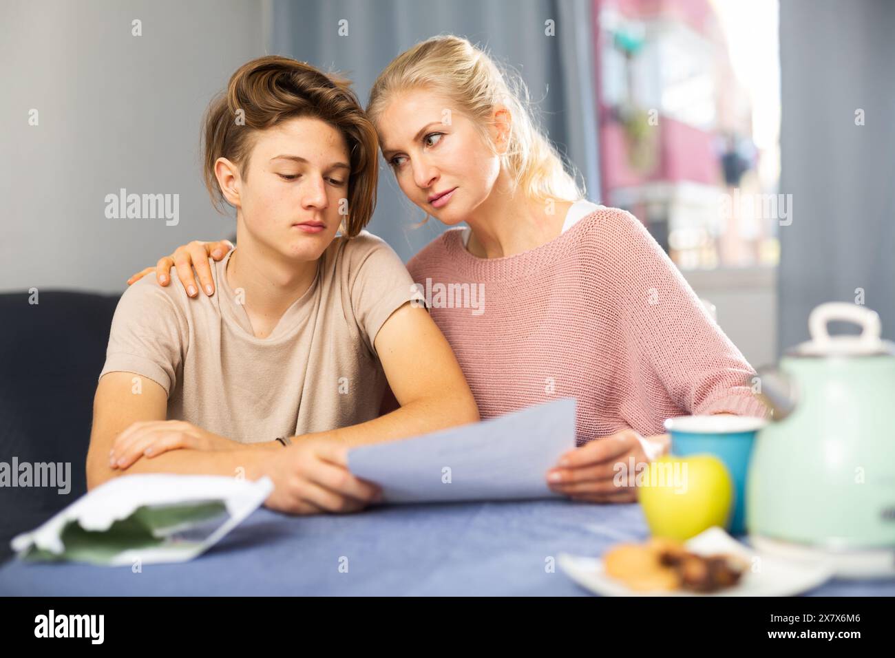 Unhappy mother and son reading letter from school Stock Photo - Alamy