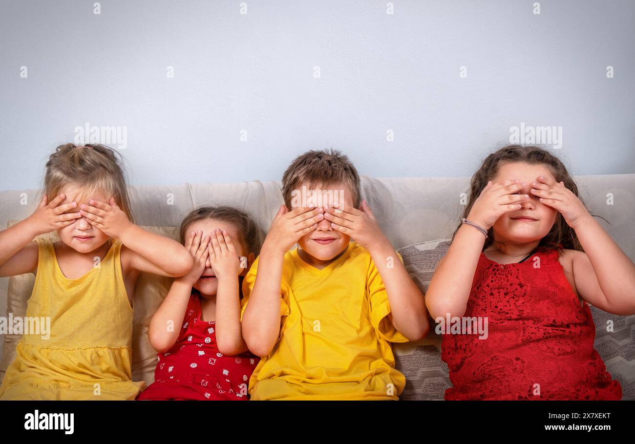 Children sitting on the sofa cover their eyes with their hands Stock ...