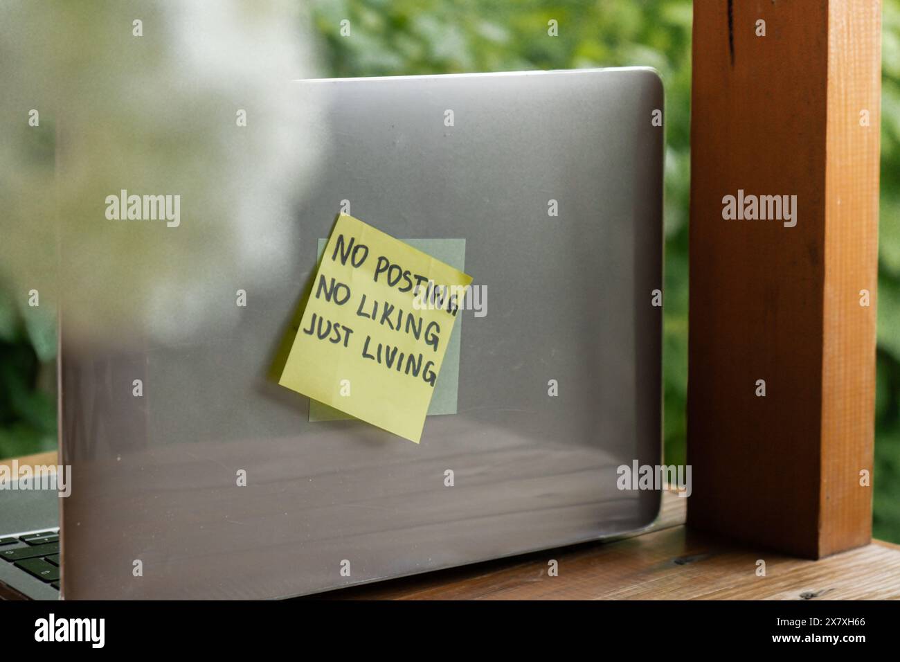 Paper note with text NO POSTING NO LIKING JUST LIVING in laptop garden ...