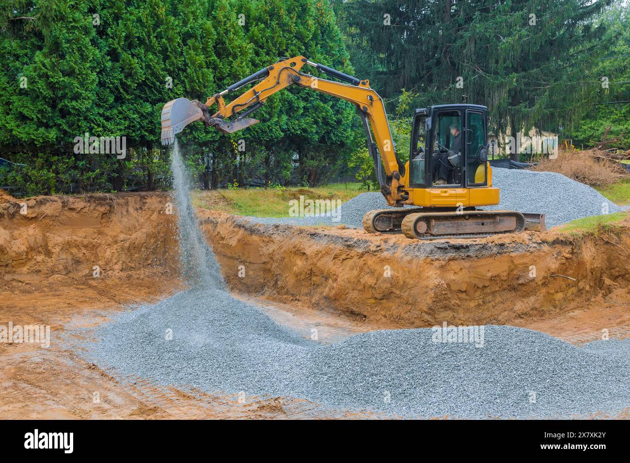 To serve as foundation for a concrete structure, excavators fill ...