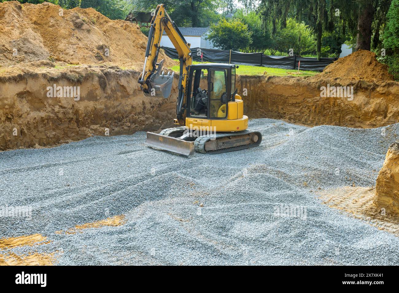 An excavator fills irregularities in excavations with granite rubble ...